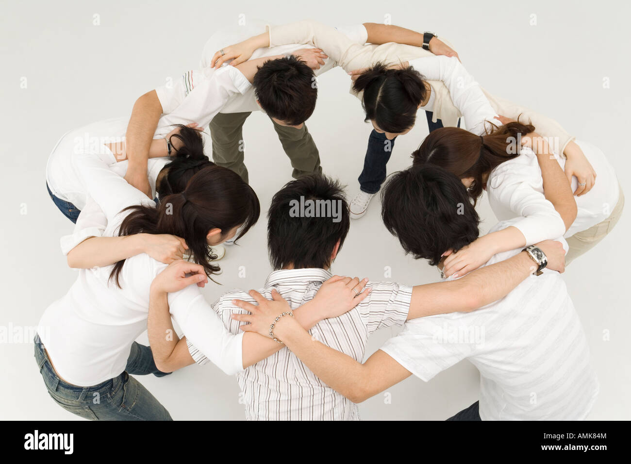 Young people huddling in circle Stock Photo - Alamy