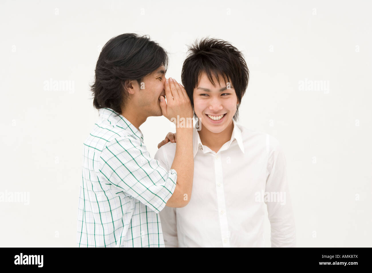Young man whispering to his friend Stock Photo - Alamy