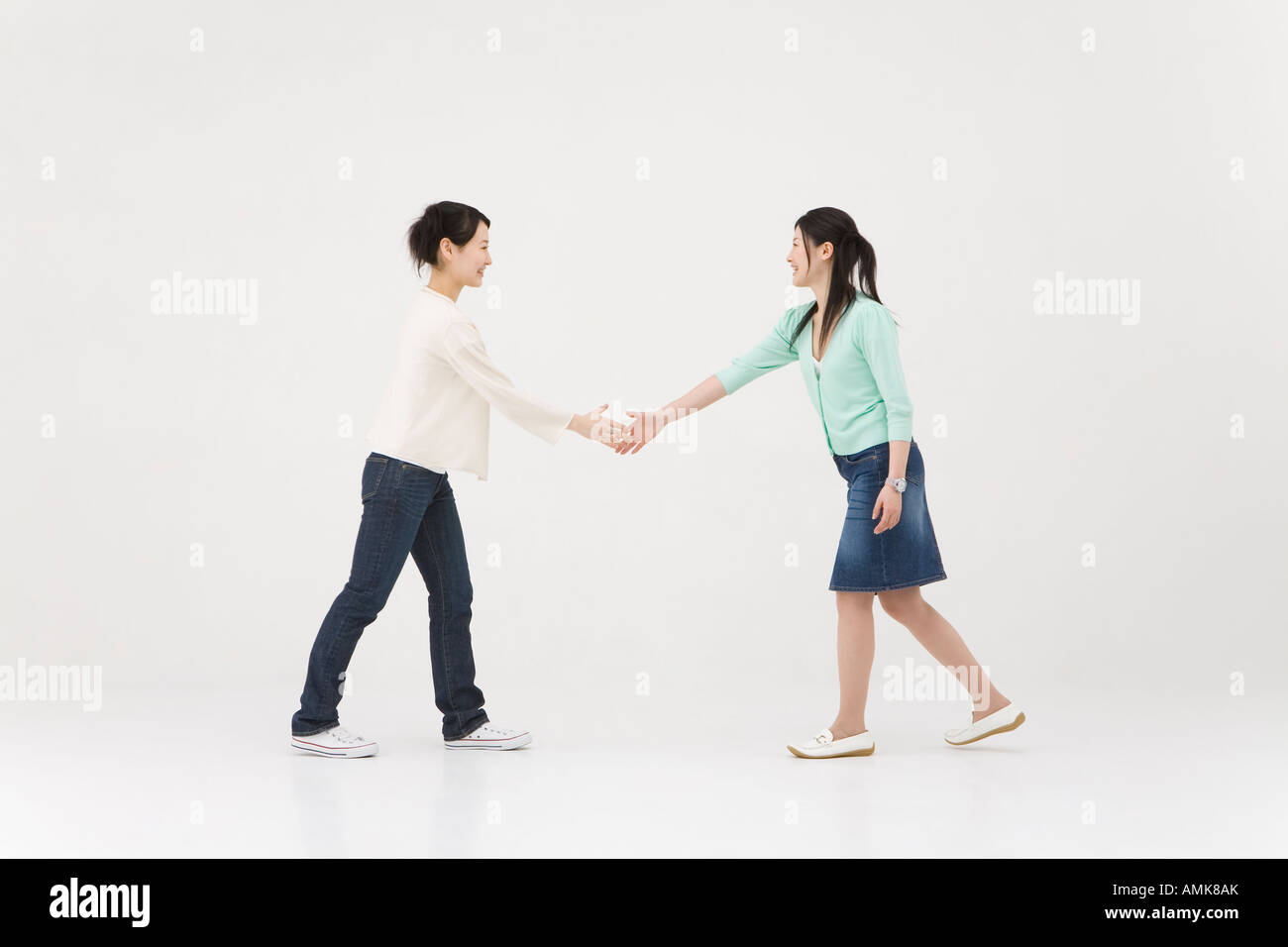 Two young women extending handshake Stock Photo - Alamy