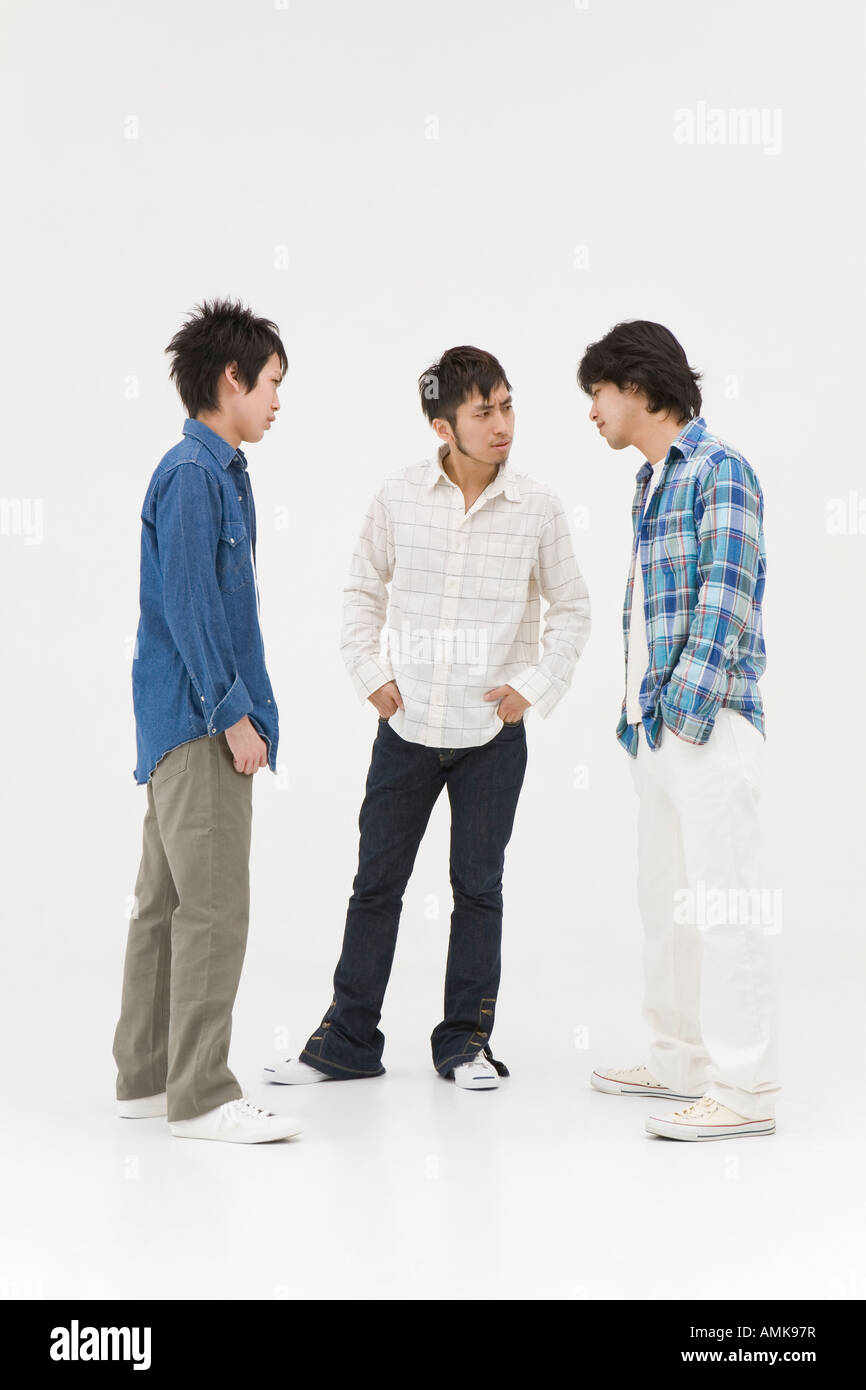Three young men glaring at each other Stock Photo - Alamy