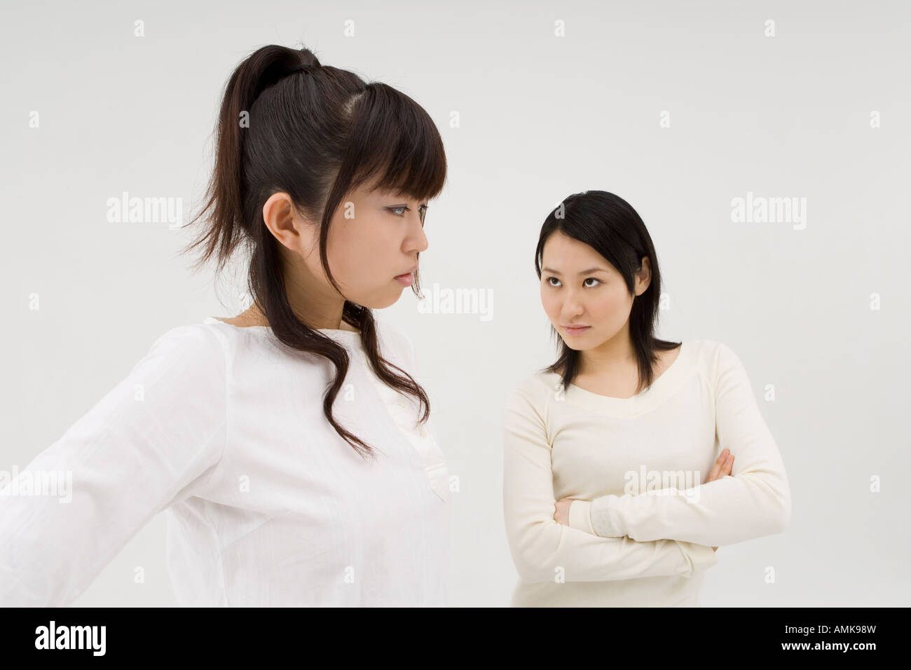 Two young women glaring at each other Stock Photo - Alamy