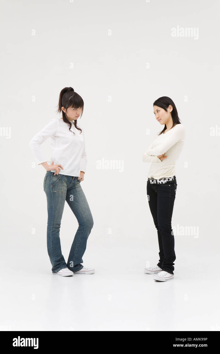 Two young women glaring at each other Stock Photo - Alamy