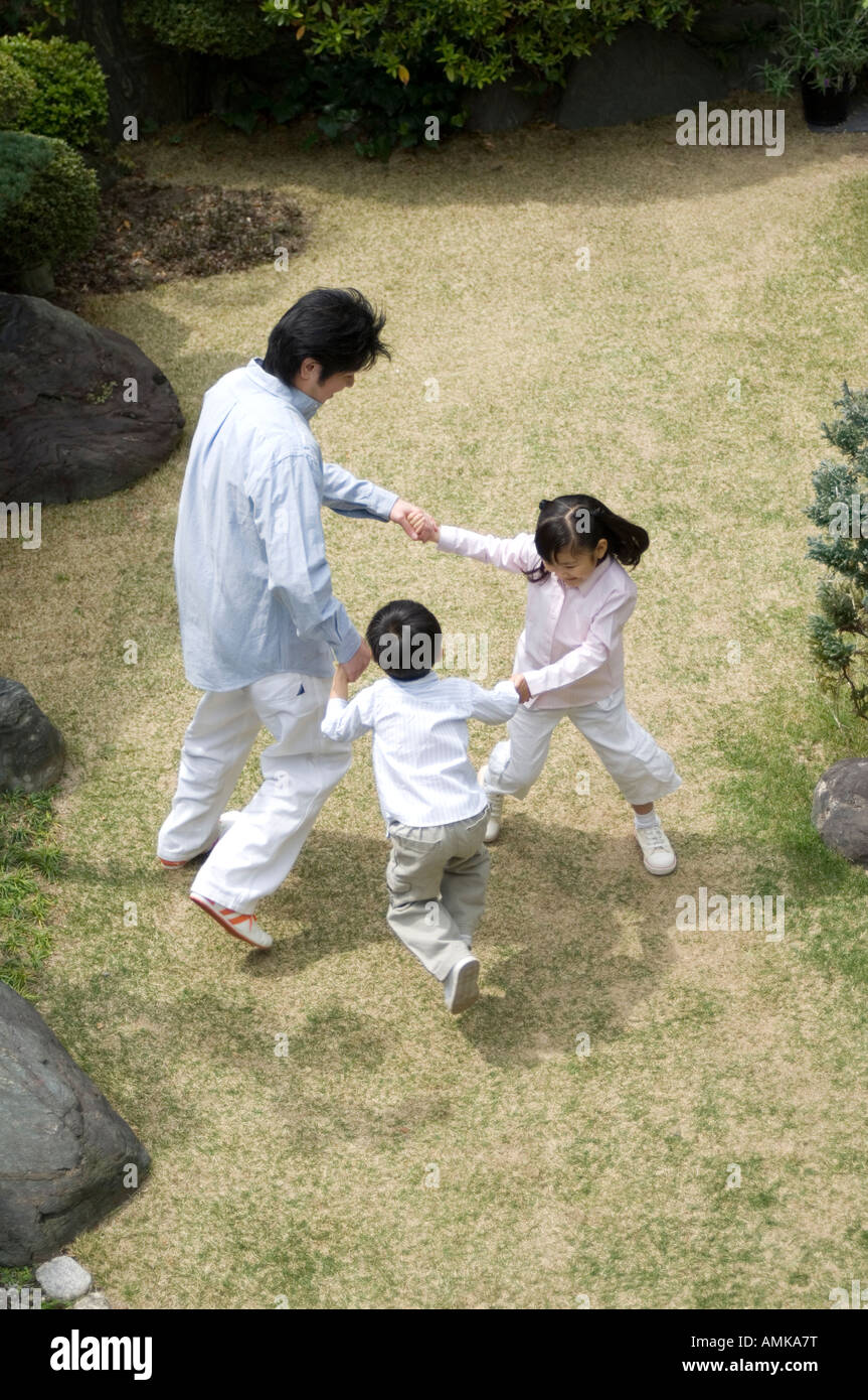 Father and children playing in garden Stock Photo - Alamy
