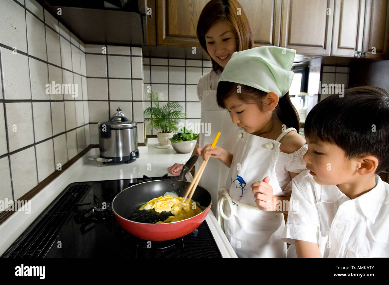 Mother and children cooking in kitchen Stock Photo - Alamy