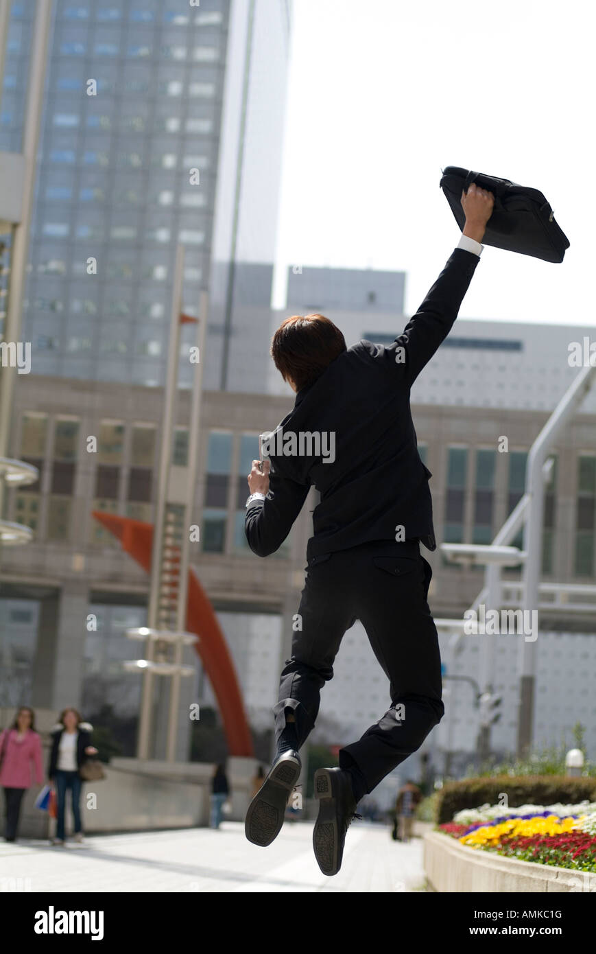 Young businessman jumping Stock Photo - Alamy