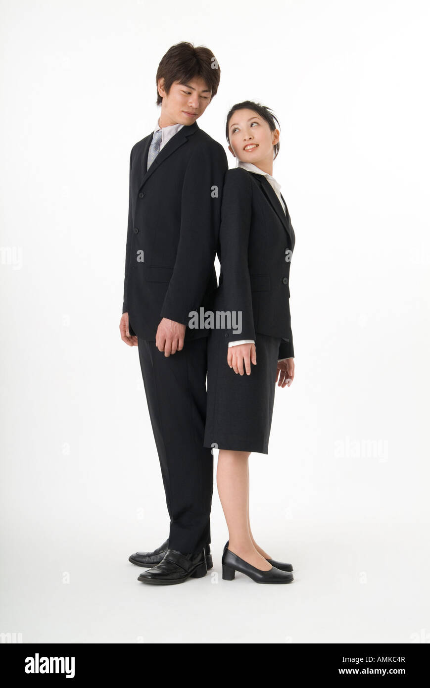 Young couple standing back to back Stock Photo - Alamy