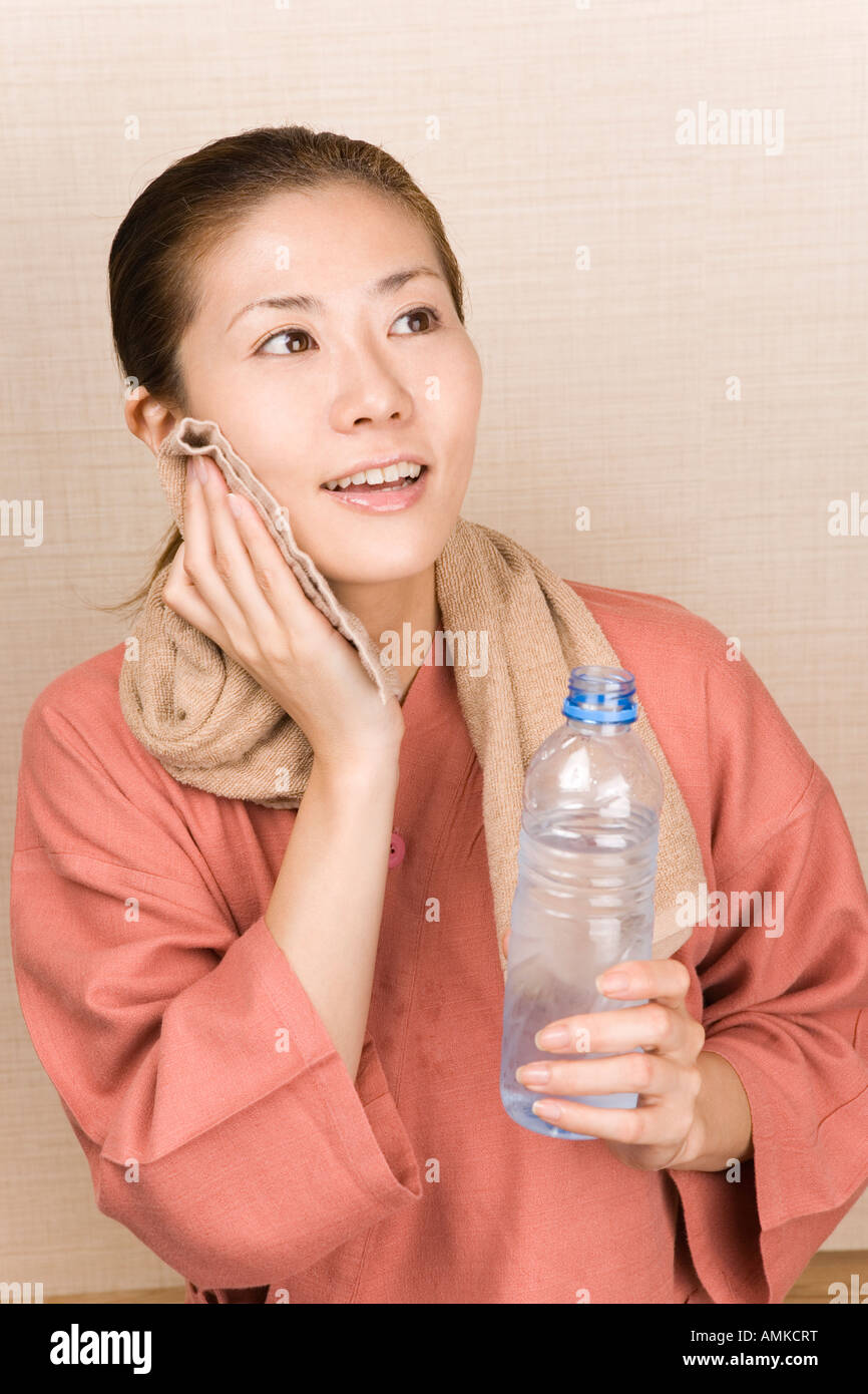 Young woman wiping face with towel Stock Photo - Alamy