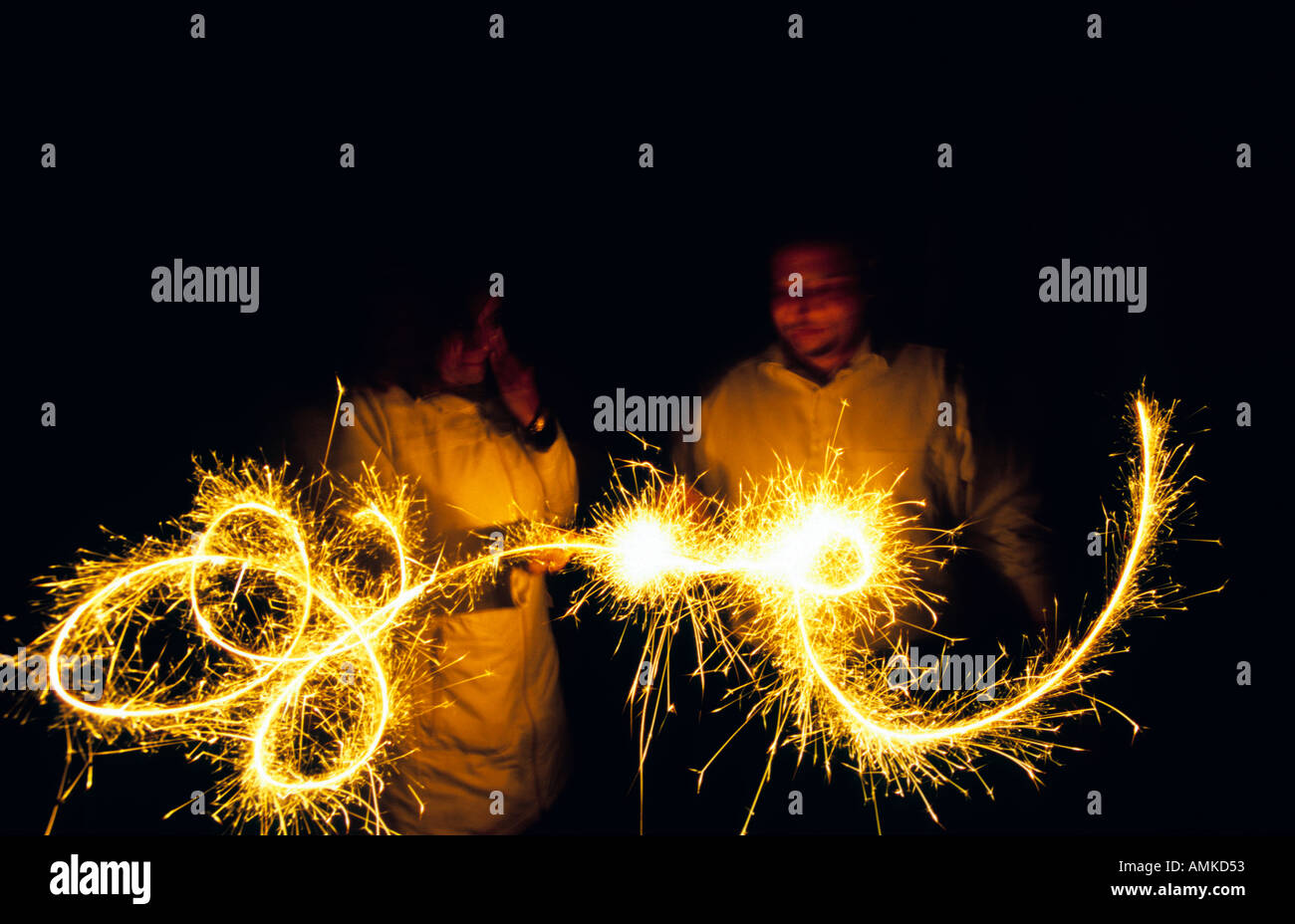 People celebrating with fireworks by night Stock Photo - Alamy