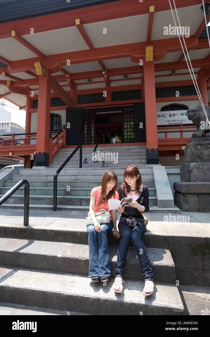 Two women looking at guidebook Stock Photo - Alamy