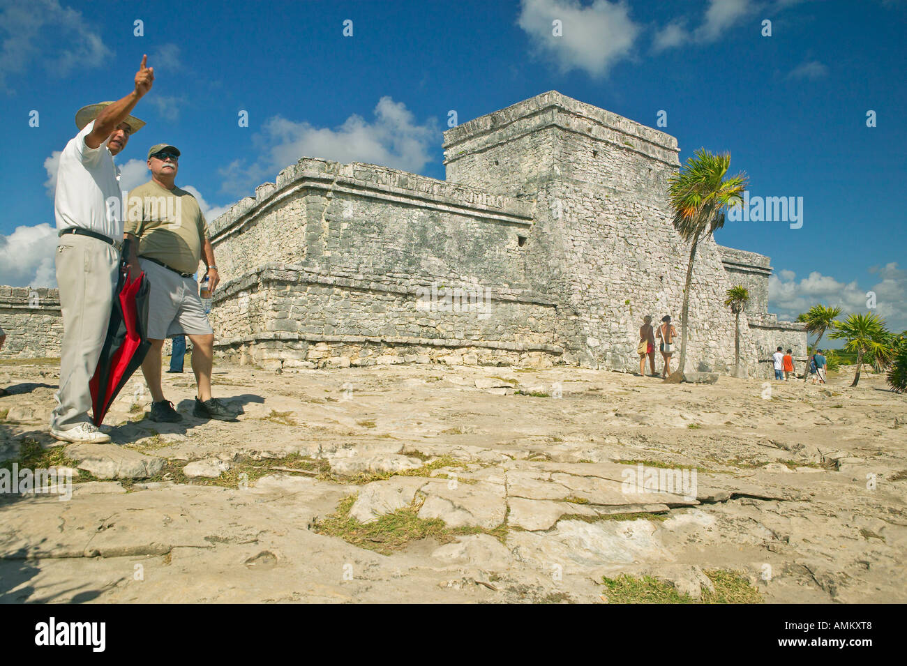 Man pointing in front of Mayan ruins of Ruinas de Tulum Tulum Ruins in ...