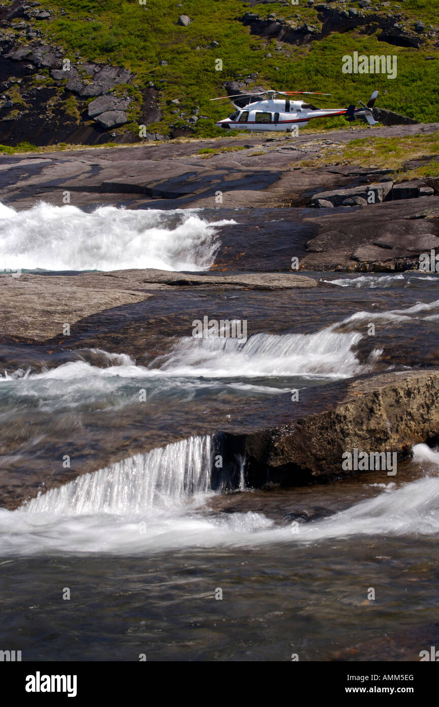 Waterfall with a helicopter in the background, Mealy Mountains in ...