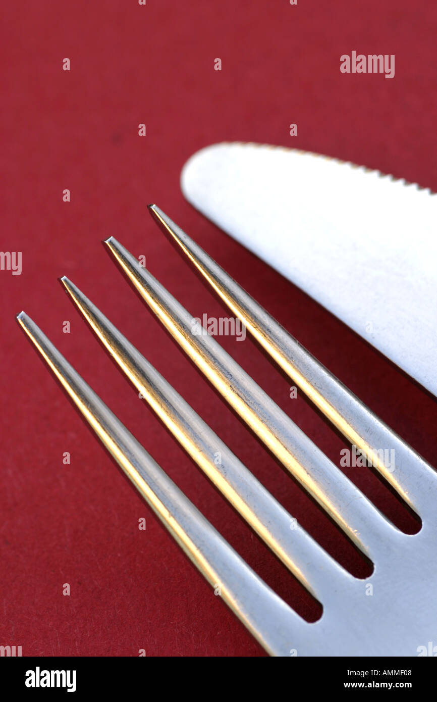 Knife and fork with red background Stock Photo - Alamy