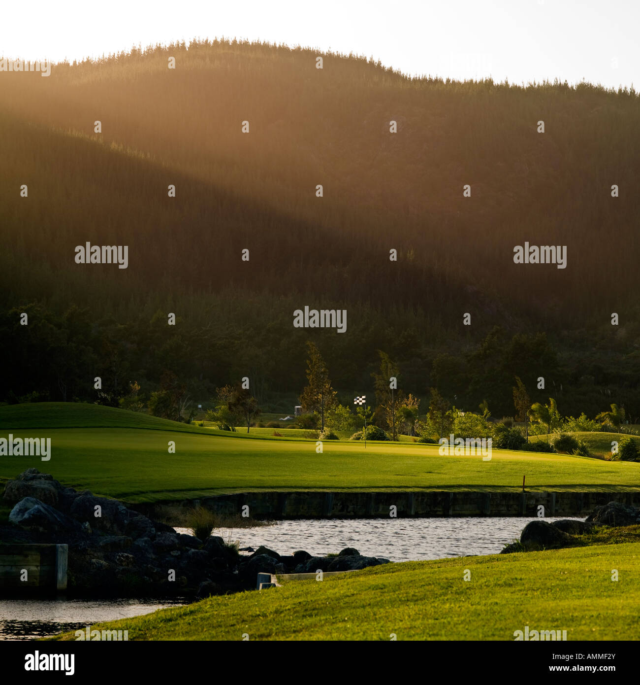 golfcourse with sunlight streaming over hills Stock Photo - Alamy