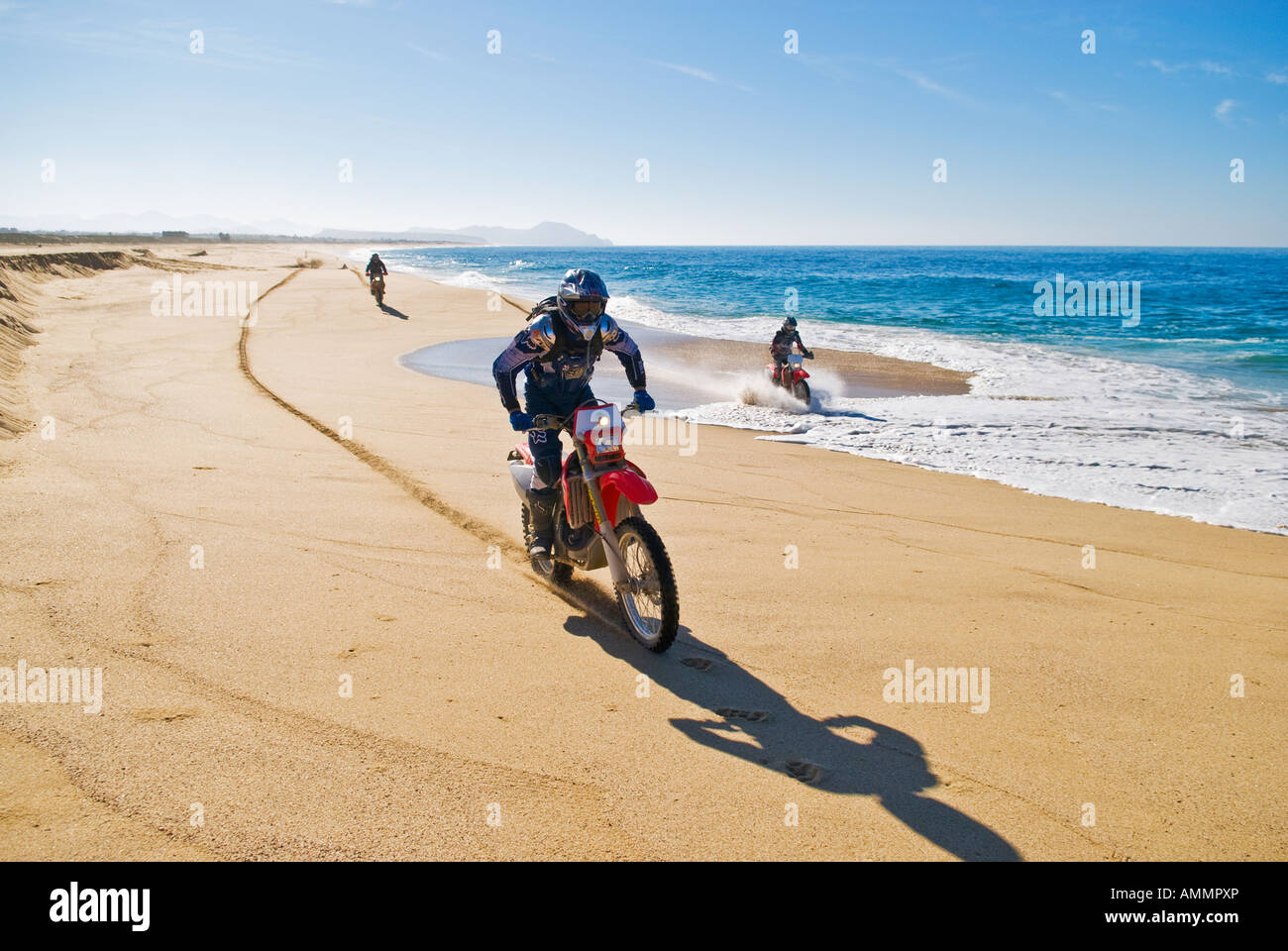 Group of off-road motorcycle riders on empty beach near Todos Santos ...