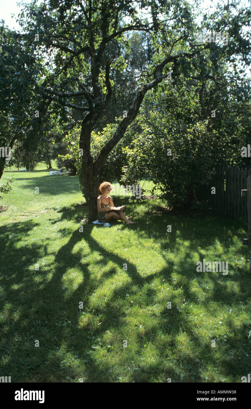 Woman sitting under tree shade hi-res stock photography and images - Alamy