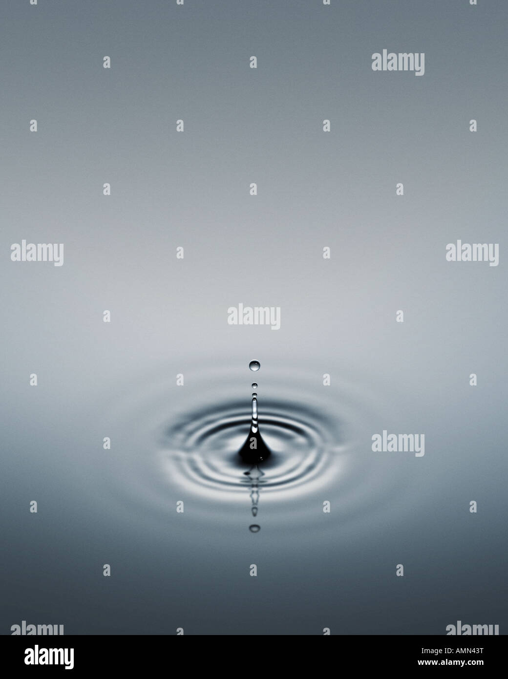A ripple of water with drops above it Stock Photo - Alamy