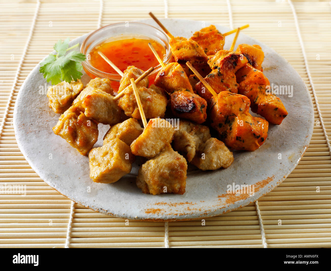Chicken satay sticks served on a plate with with dipping sauce Stock ...