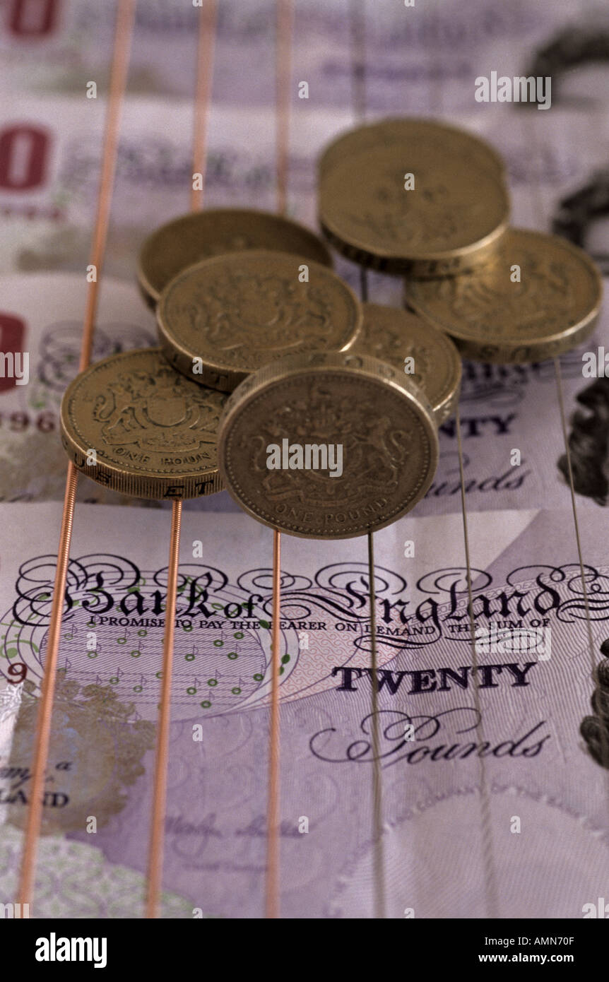 One pound coins balanced over twenty pound notes Stock Photo - Alamy