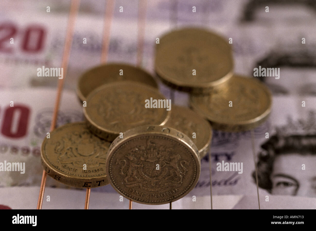 One pound coins balanced over twenty pound notes Stock Photo - Alamy