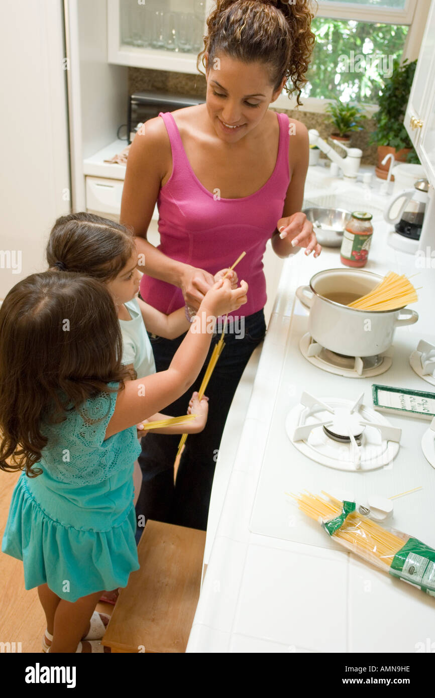 Mother and daughters cooking pasta together Stock Photo - Alamy