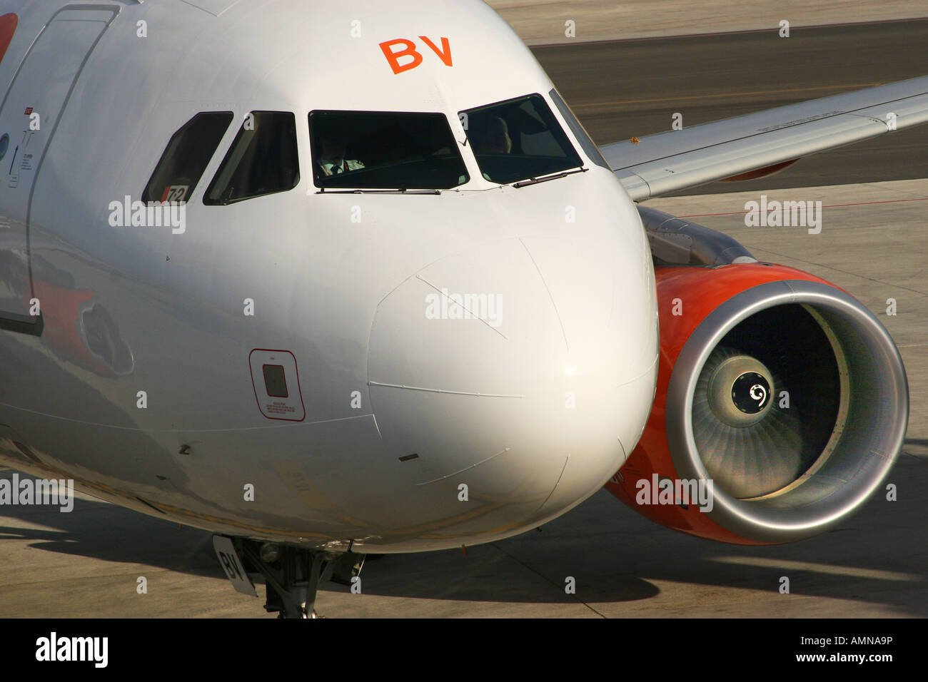 Cockpit area and one engine of passenger jet parked at airport Stock ...