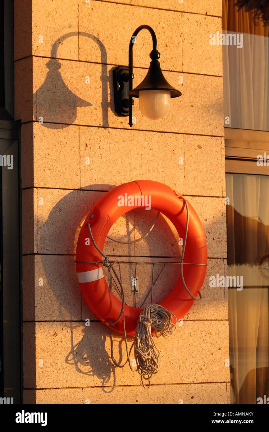 Early morning shot of light fitting and life saving ring with rope on ...