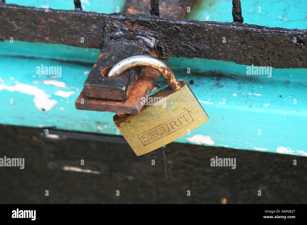 Brass security padlock in closed position holding grill onto shop front ...