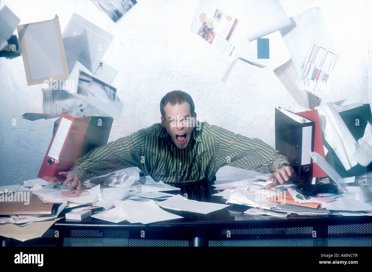 A desperate man demolishing his desk and screaming Stock Photo - Alamy
