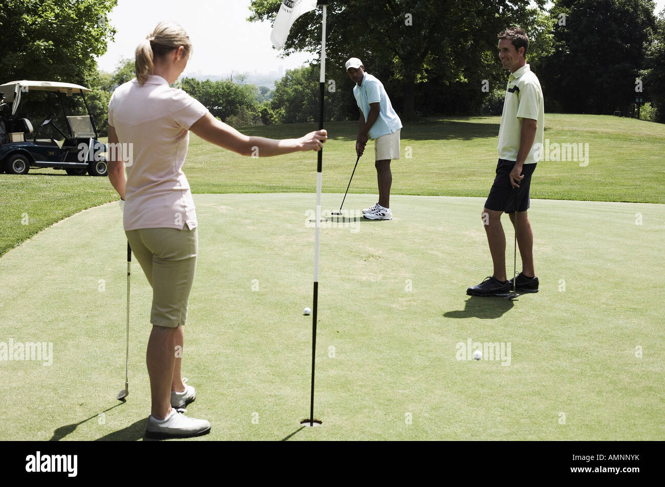 Female Golfer Putting Ball In Hole High Resolution Stock Photography ...