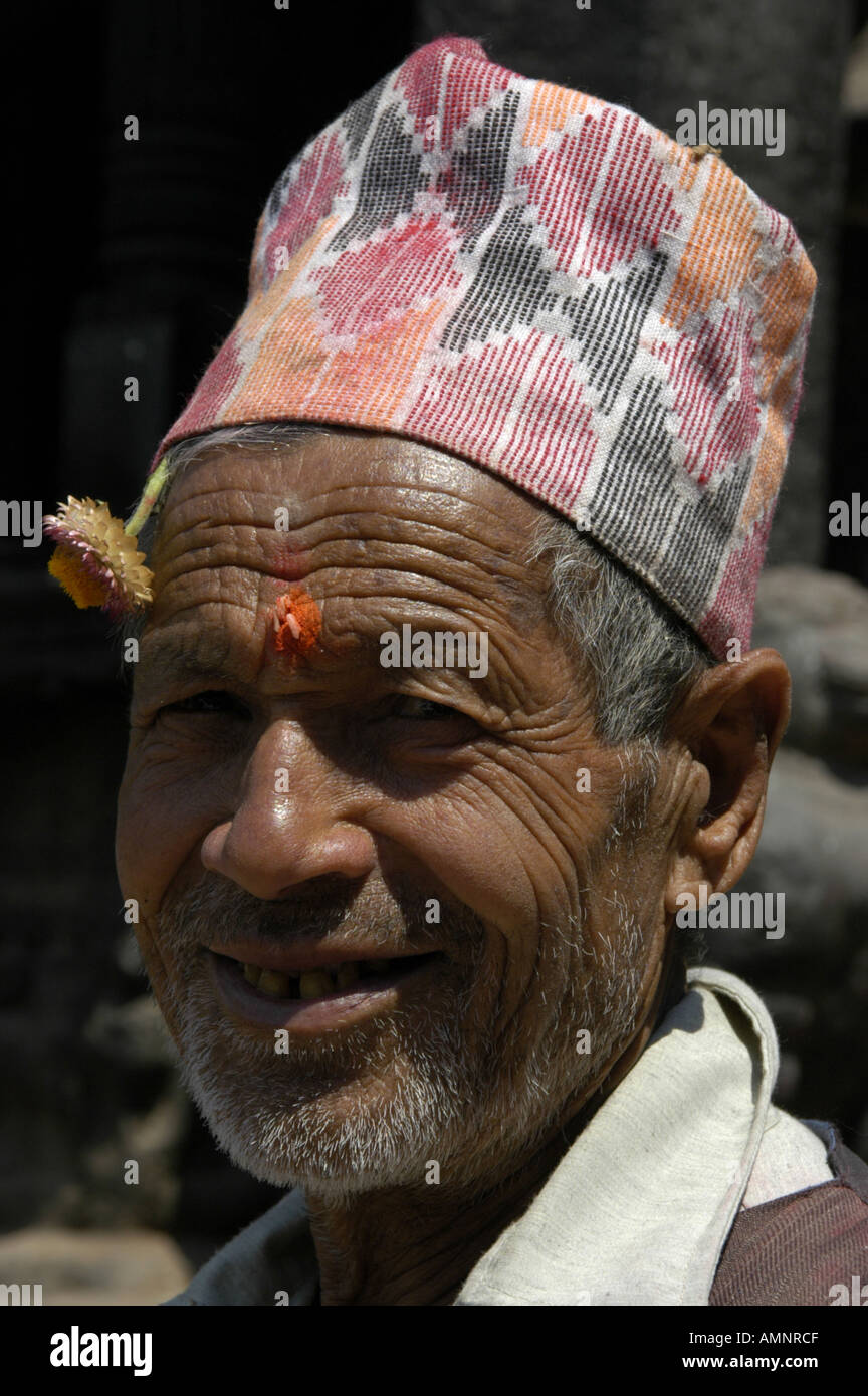 Portrait Newari man with traditional hat and flower on his forehead ...