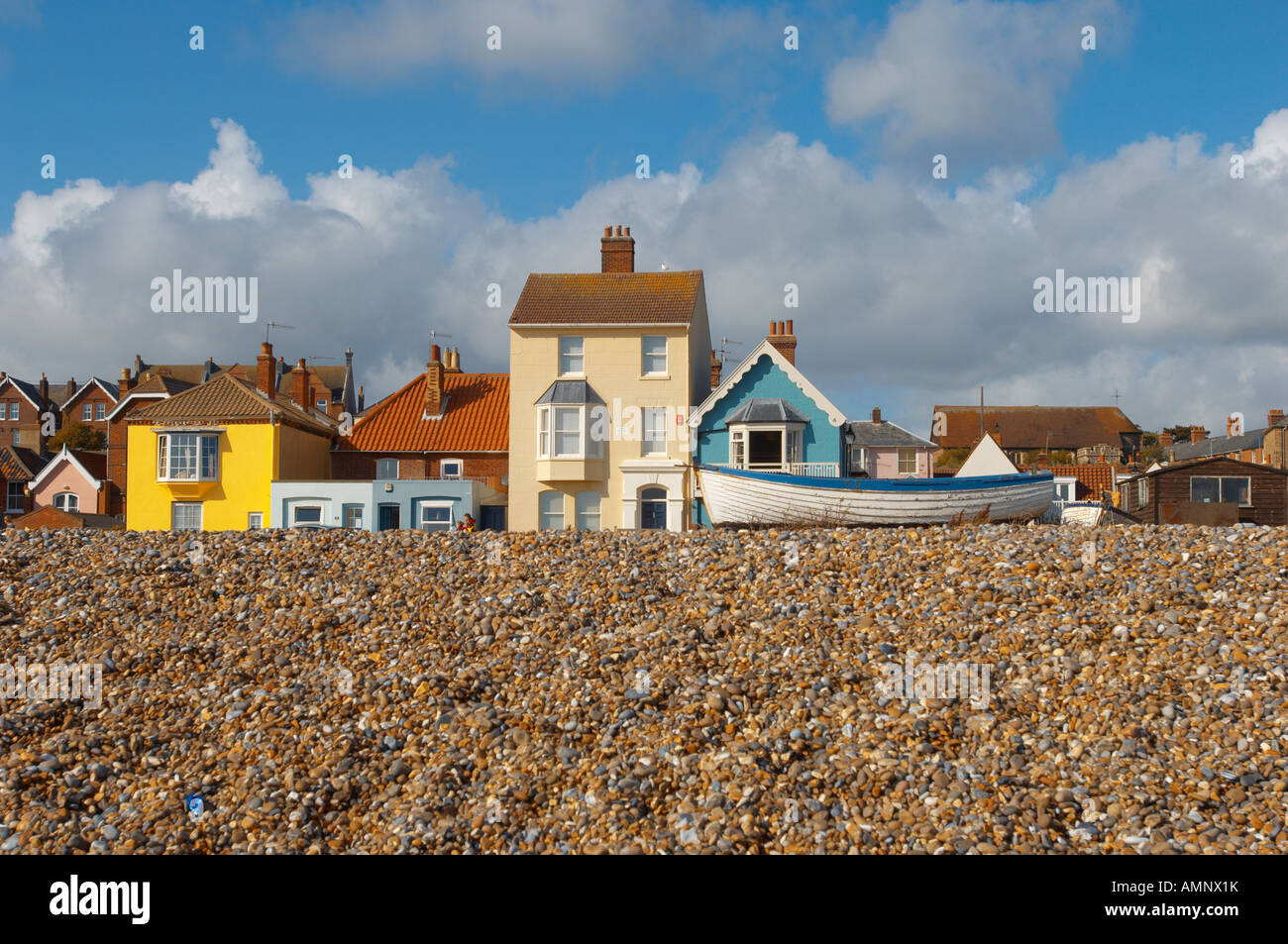 Brightly colored painted house and cottage on the sea front beach at ...