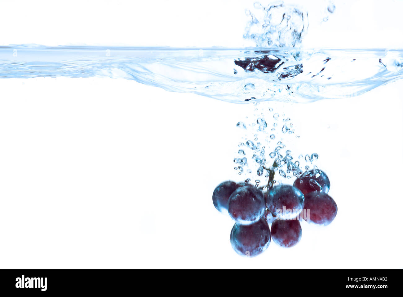 Red grapes splashing into water Stock Photo - Alamy