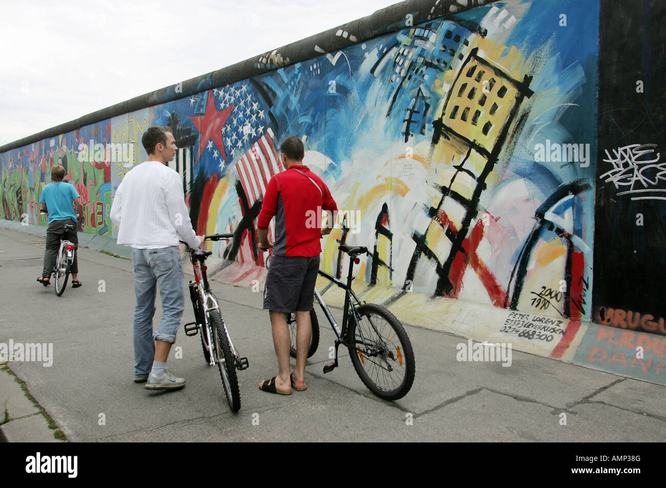Young people in front of the painted Berlin Wall, Germany Stock Photo ...