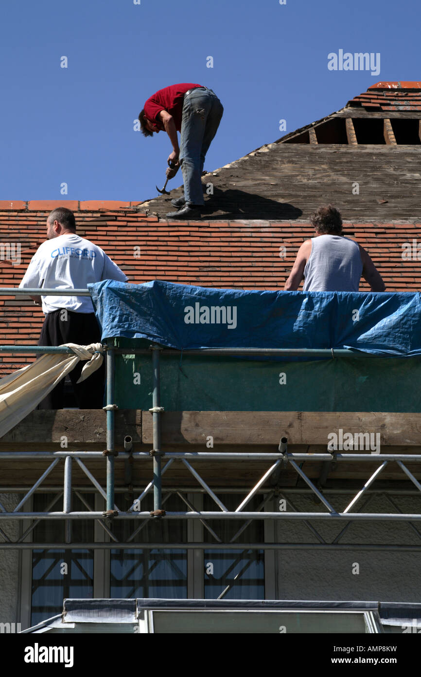 Tiler removing old Tiles from Roof of House Stock Photo - Alamy