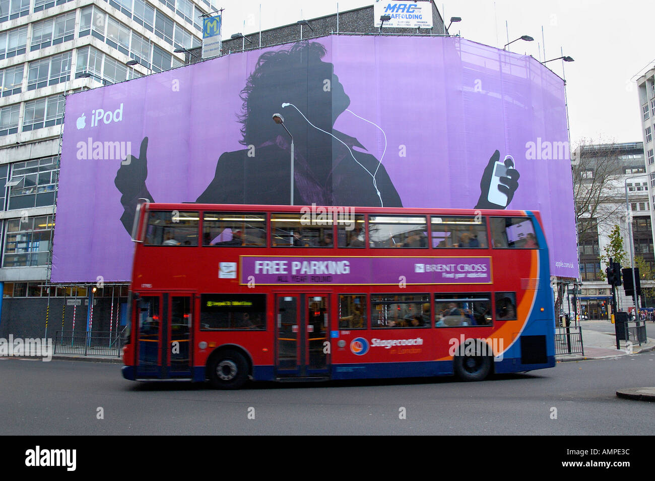 A huge billboard advertising the Apple iPod with a double decker bus in ...