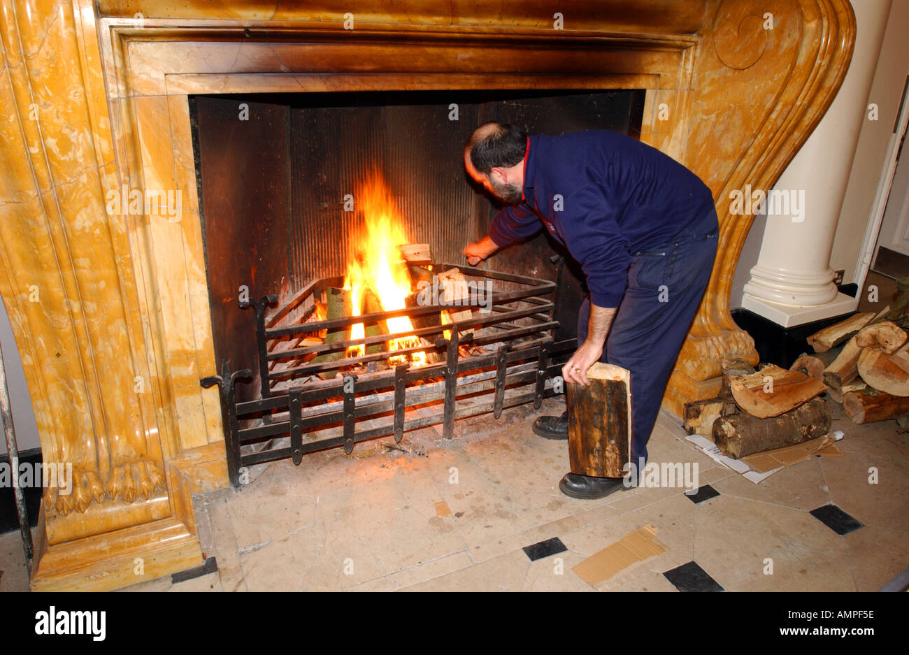 A man tends to an open fire Stock Photo - Alamy