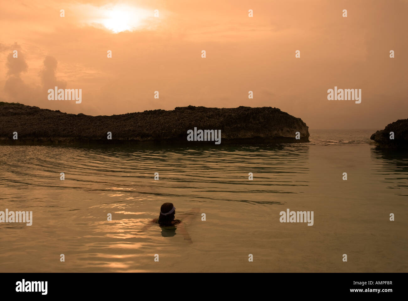 Woman in sea at sunset, Long Island, Bahamas Stock Photo - Alamy