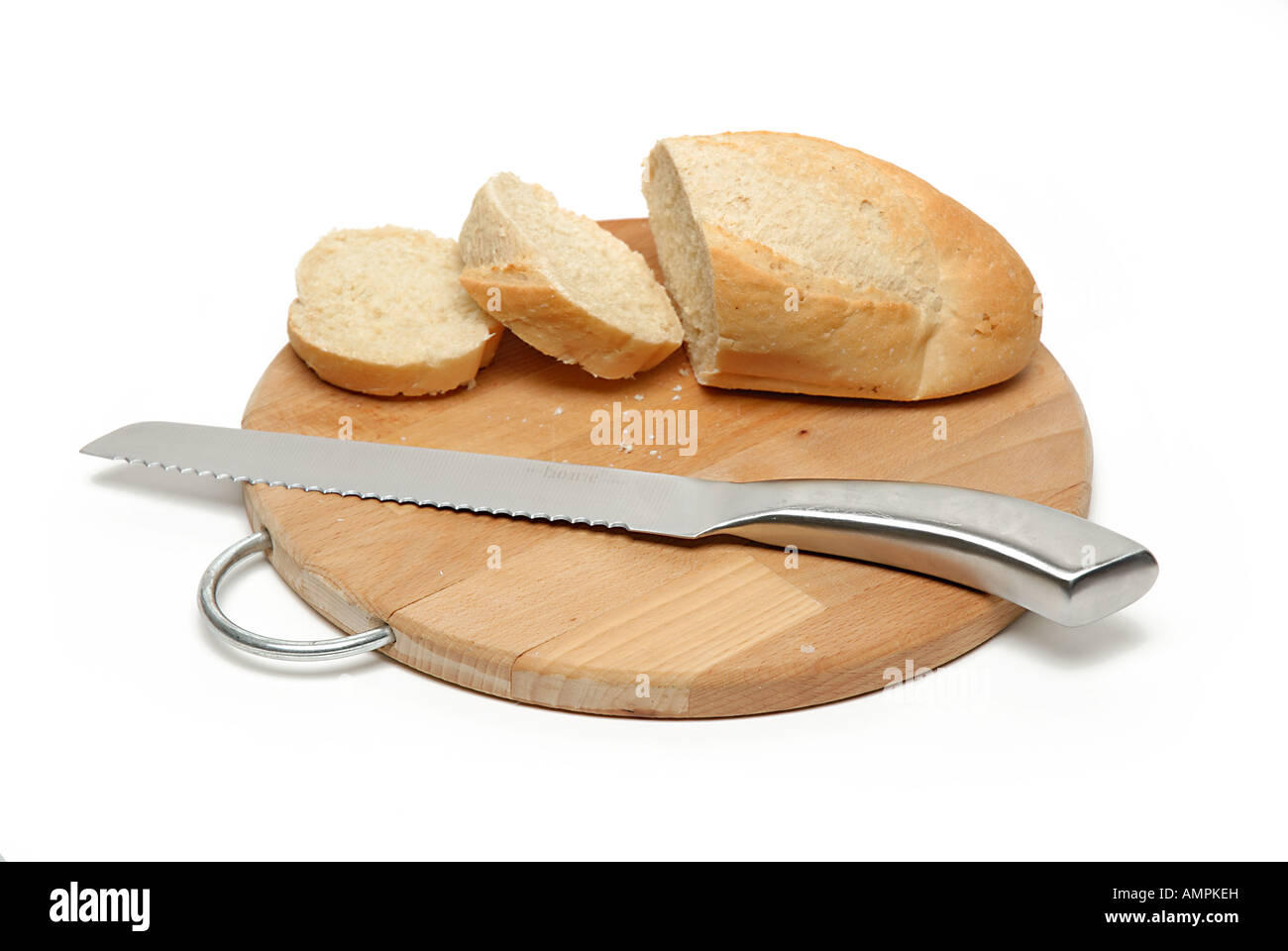 Circular wooden breadboard with loaf, slices of breas and silver bread ...