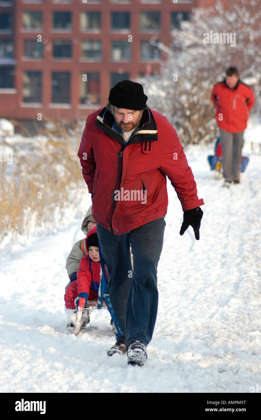 Two men and kids with a sledge Stock Photo - Alamy
