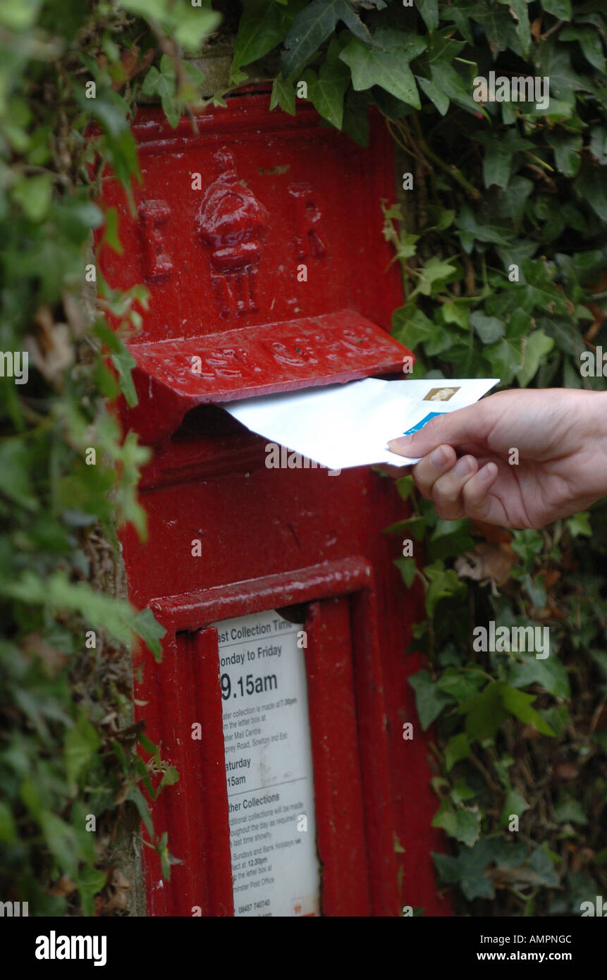 A letter is posted in a rural postbox in Britain Stock Photo - Alamy