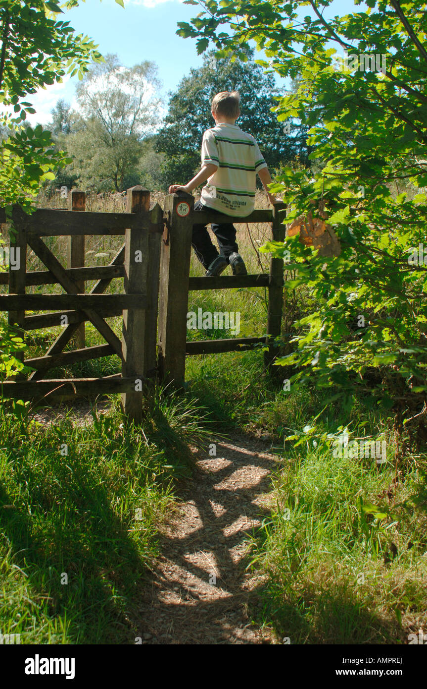 Boy sitting on wooden gate hi-res stock photography and images - Alamy
