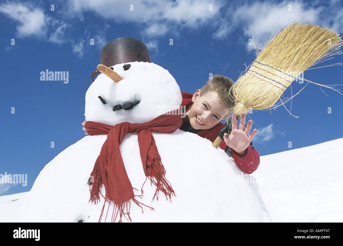 Boy standing behind snowman with broomstick Stock Photo - Alamy