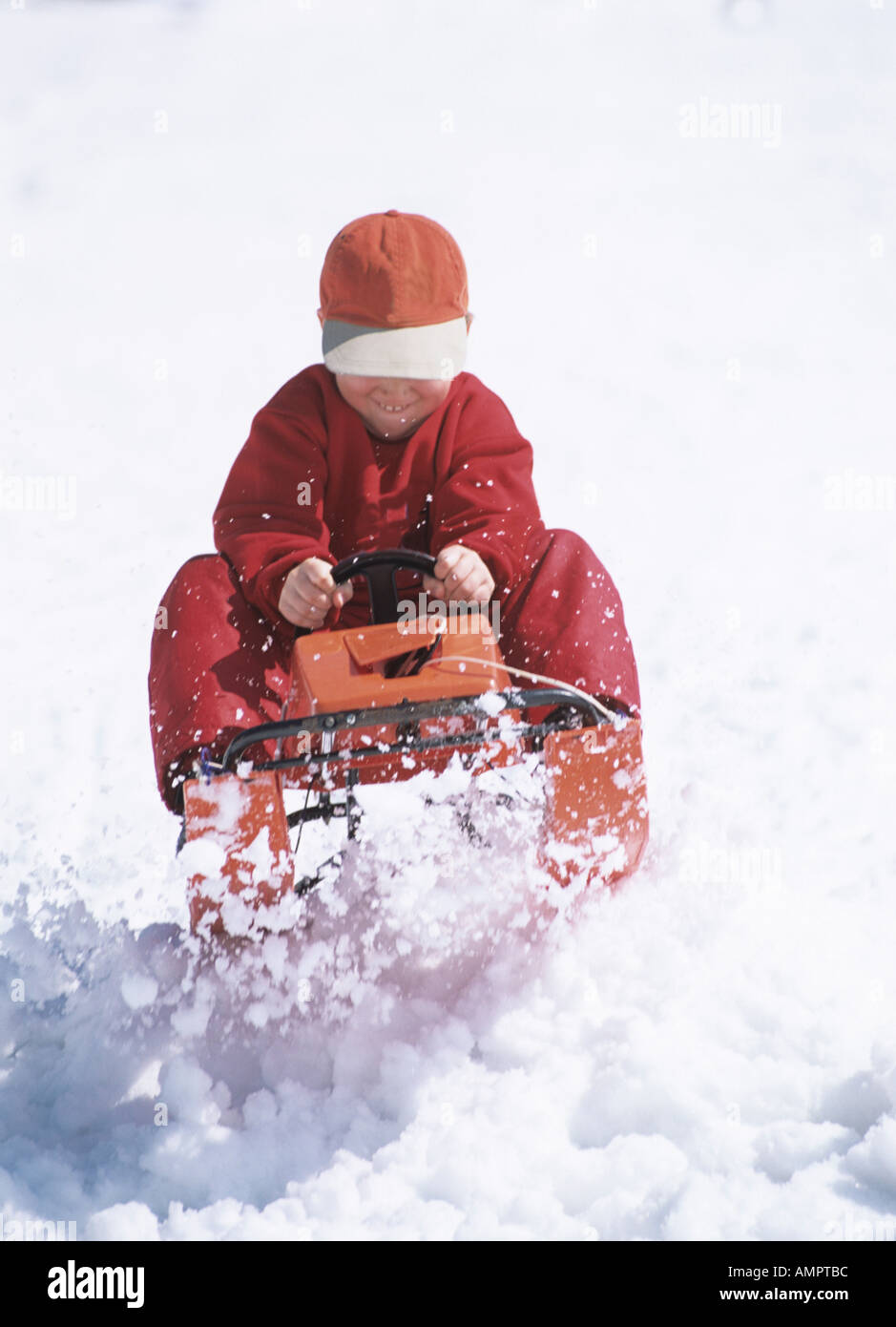 Boy riding sledge Stock Photo - Alamy