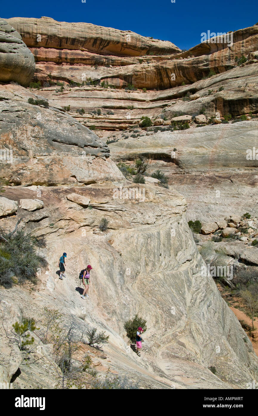 boy mom and sister hiking down sleep slope in natural bridges monument ...