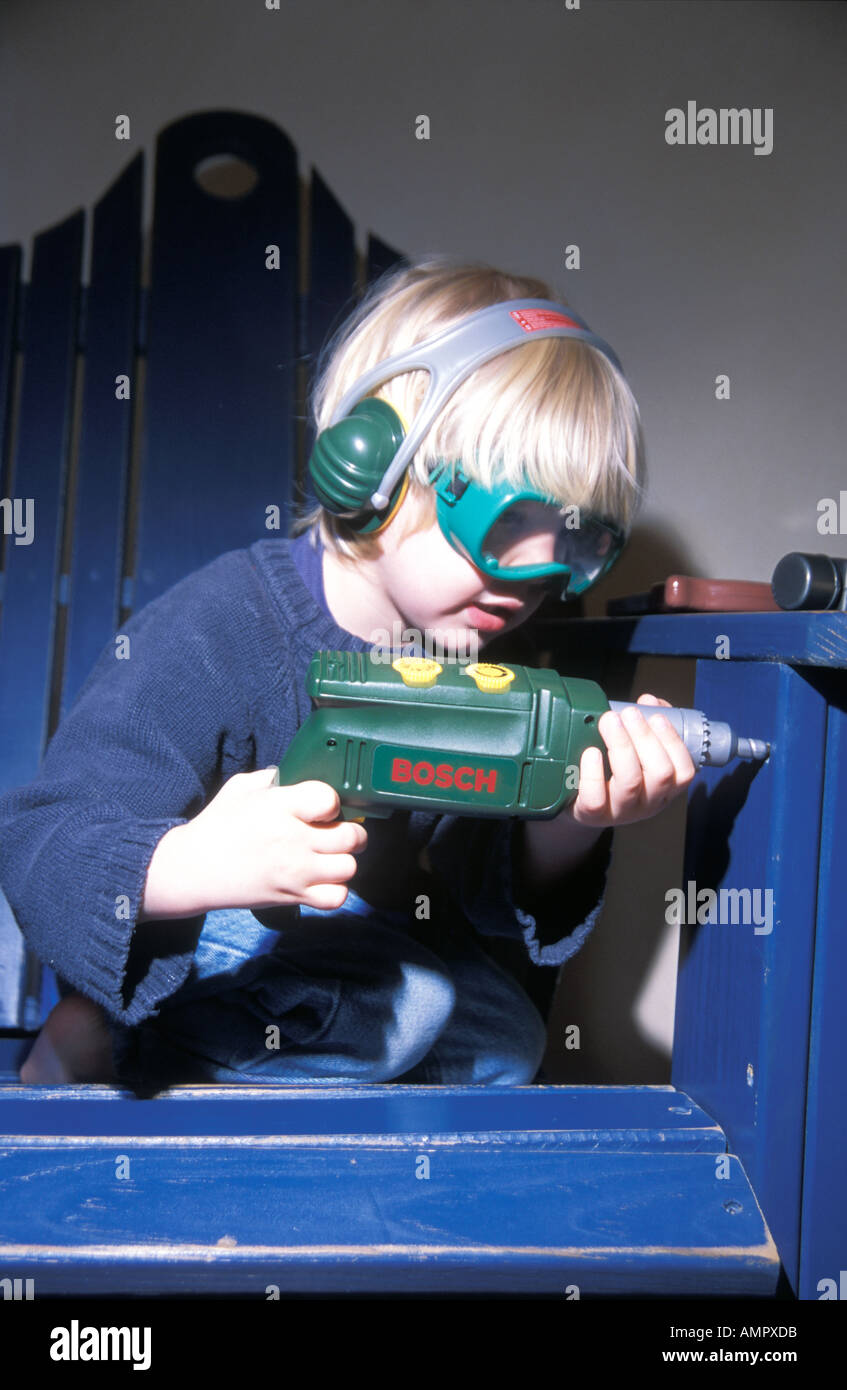 Boy playing with toy drill machine Stock Photo - Alamy