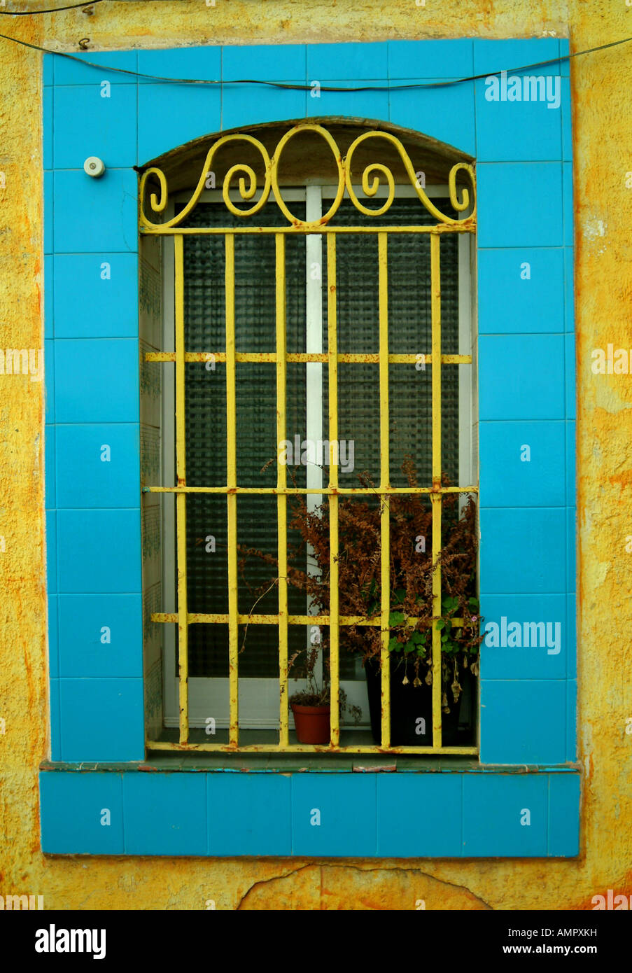 Bright blue painted window on yellow wall on a house in the area of ...