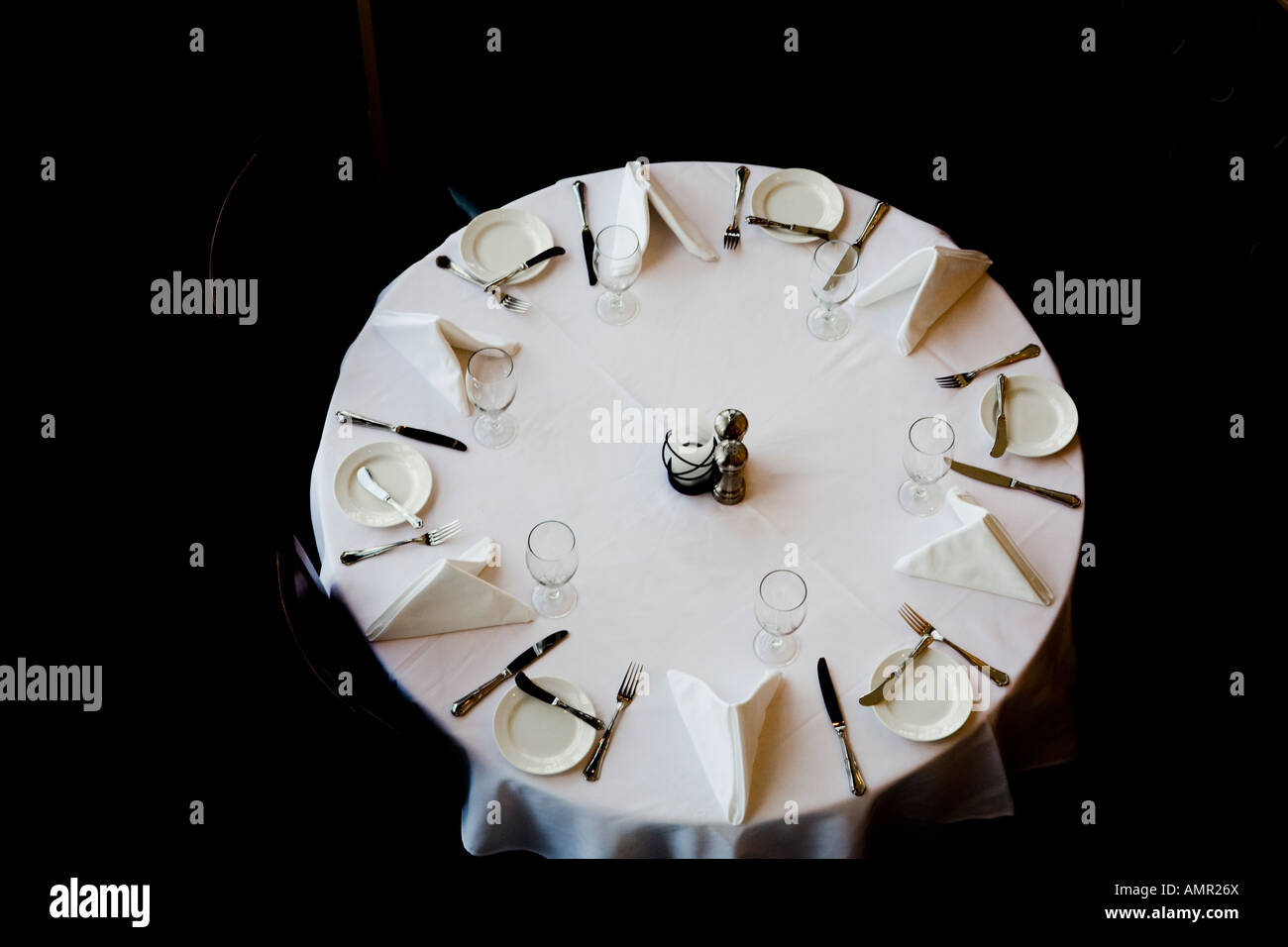 A round table set for dinner Stock Photo - Alamy