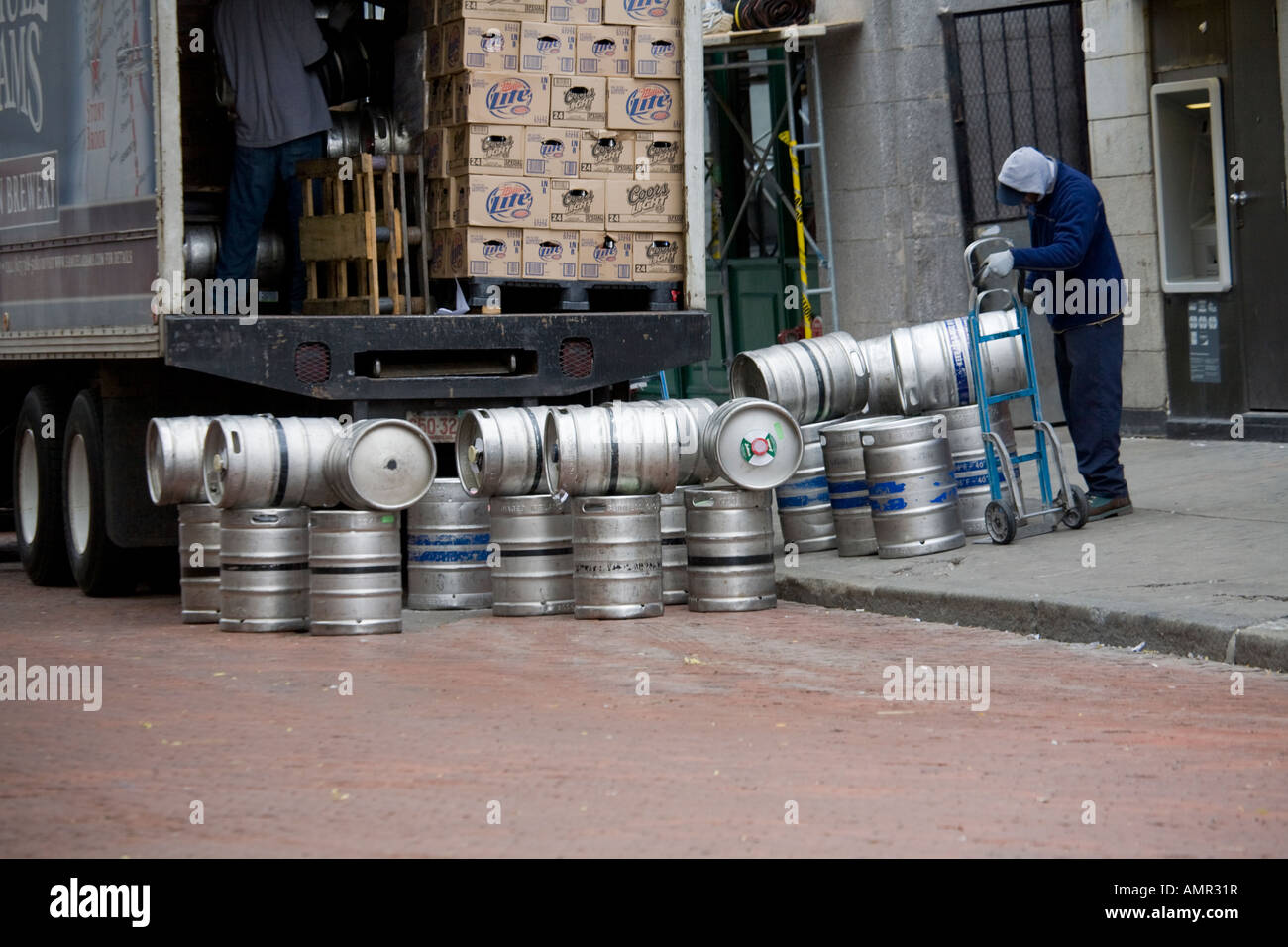 A man unloading beer barrels in a back street in Boston Massachusetts ...
