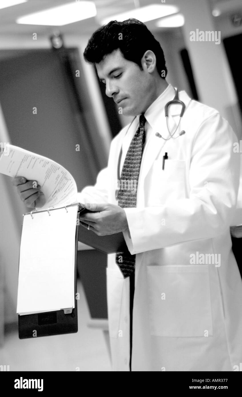 Doctor looking at patient chart Stock Photo - Alamy