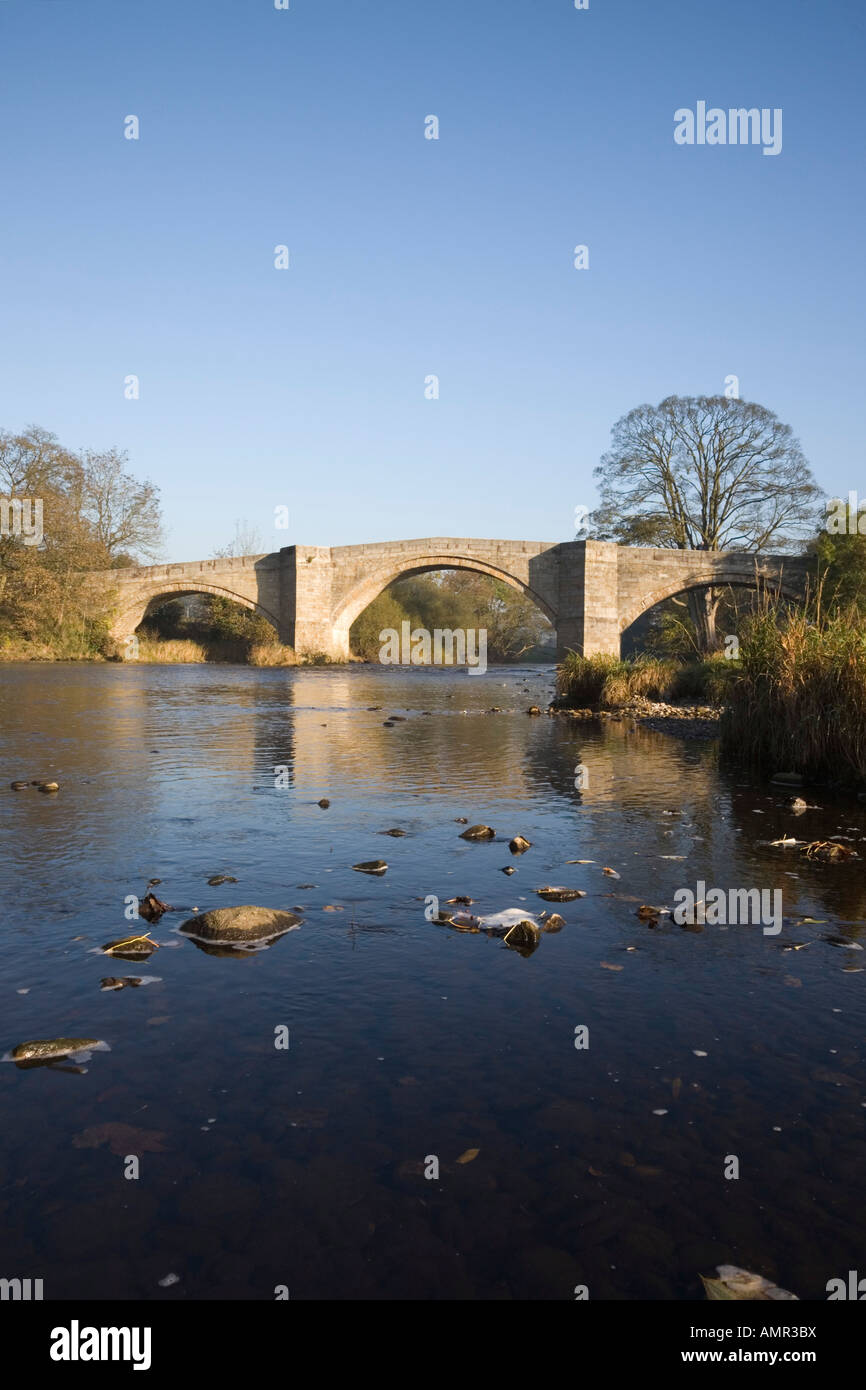 Old arched stone packhorse bridge over River Wharfe in Yorkshire Dales ...